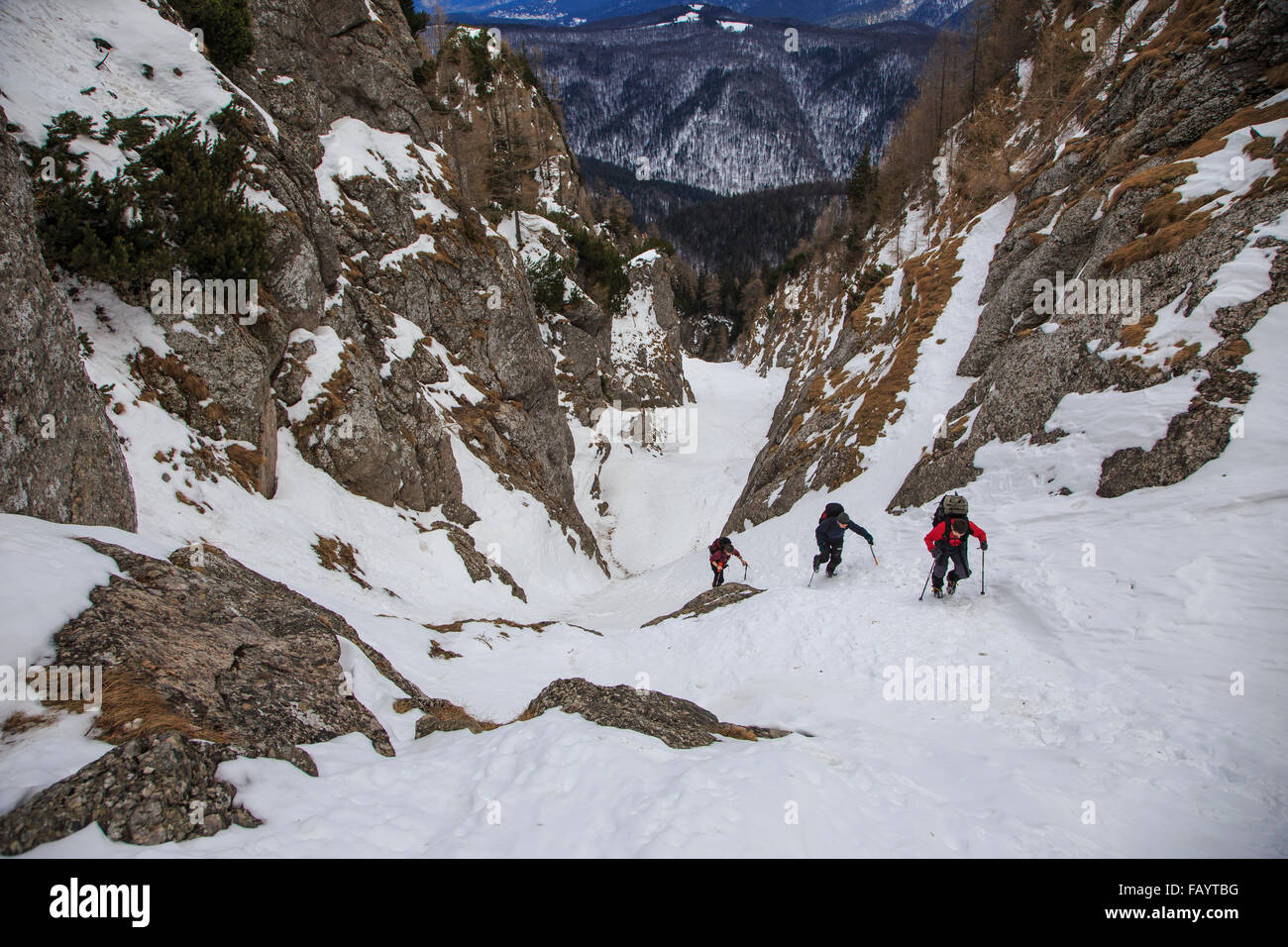 Climbers ascending steep mountain valley Stock Photo - Alamy