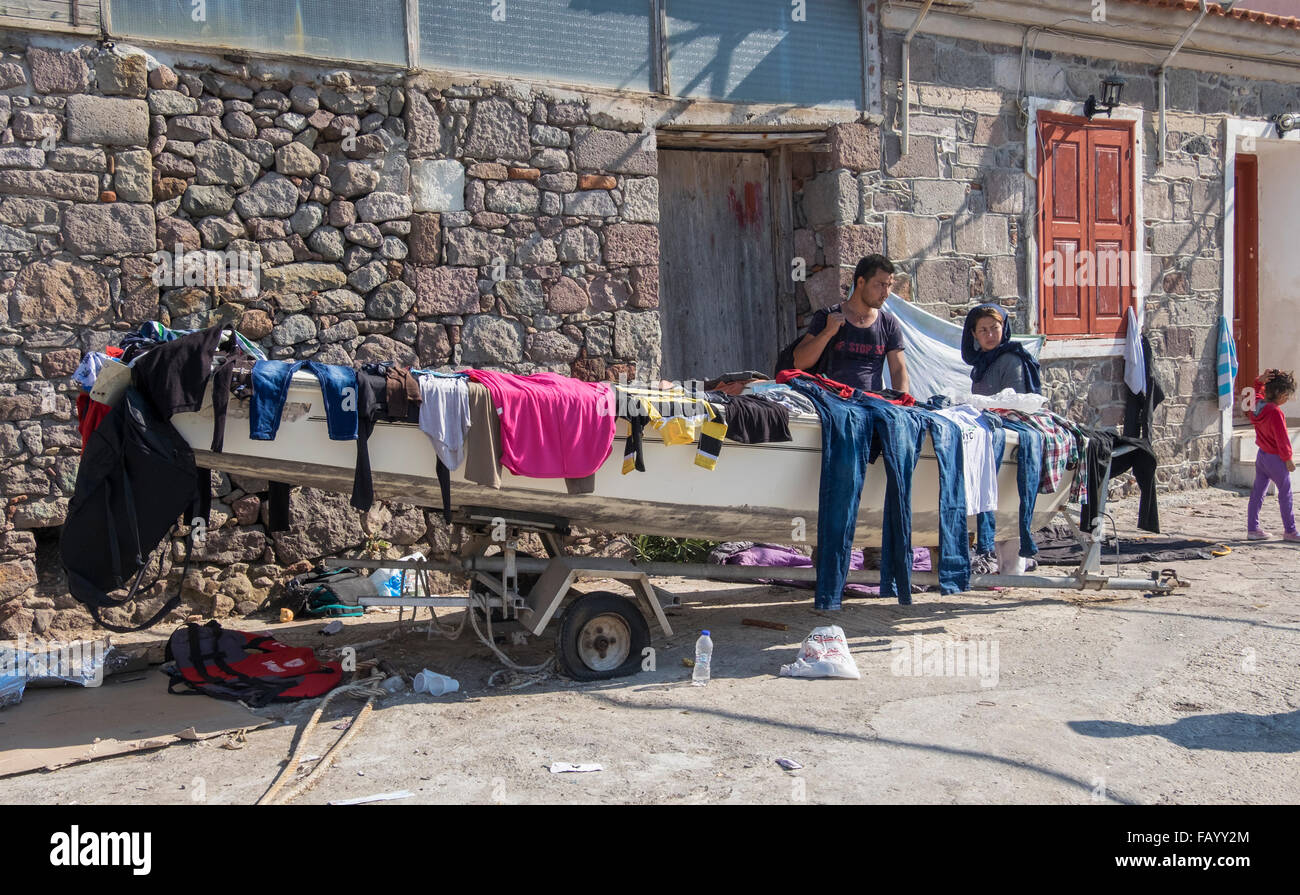 Syrian refugees dry their clothing on a drydocked boat after crossing ...