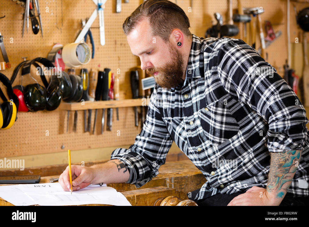 Carpenter planning new work in the workshop Stock Photo - Alamy