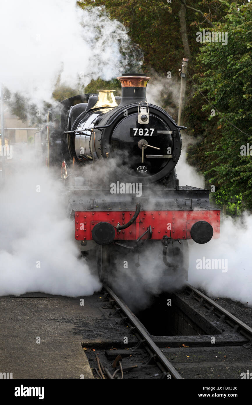 7827 Lydham Manor steam locomotive passes a rake of carriages at ...