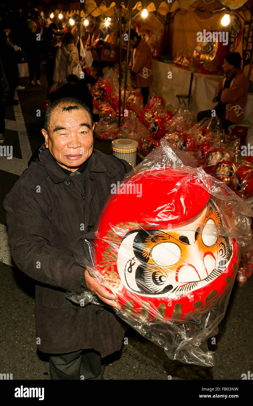 A man shows a huge Daruma doll outside the Shorinzan Daruma Temple in ...