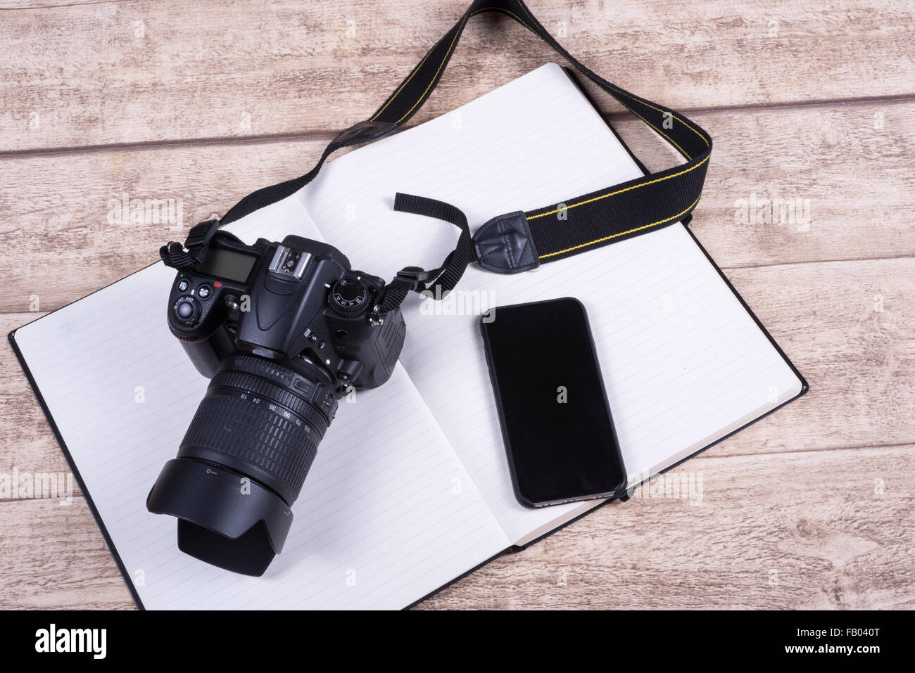 Photographers workplace with book, phone and camera on wooden table ...