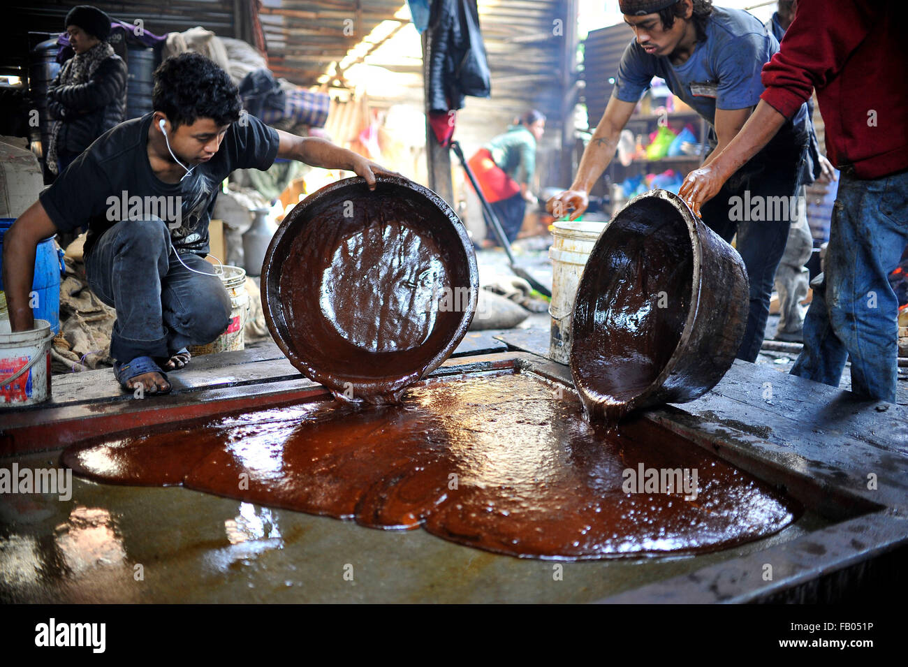 Locals put the molten raw hardened molasses or “Chaku” in a molder to ...
