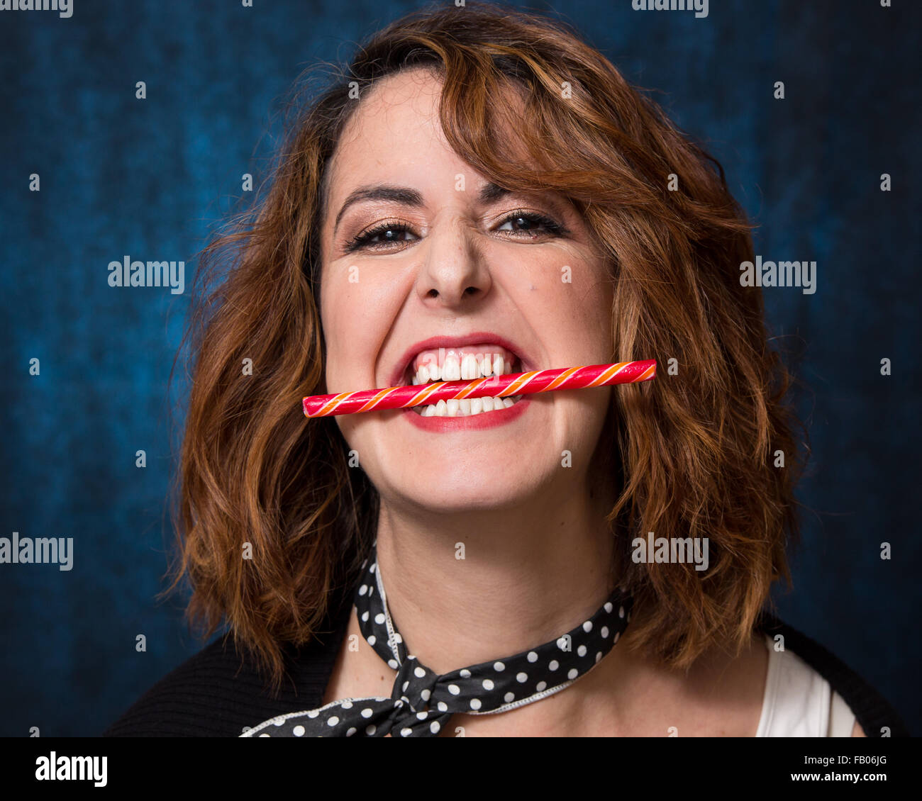 Mature woman holds candy cane with her strong white teeth Stock Photo ...