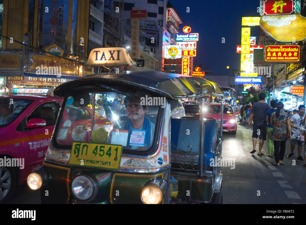 Tuk tuks and taxis in the street. View down Thanon Yaowarat road at night in central Chinatown ...