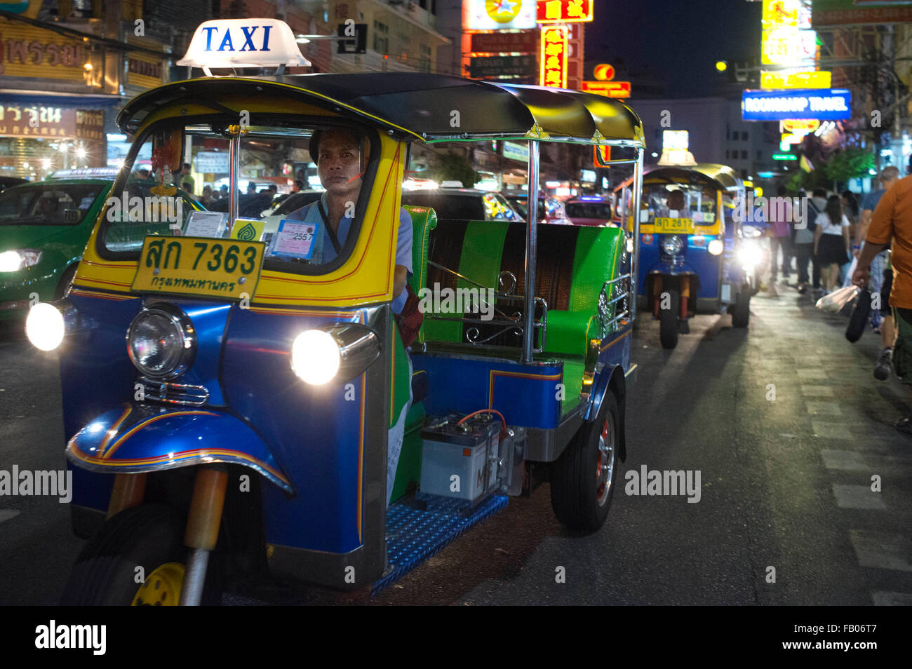 Tuk tuk taxi in the street. View down Thanon Yaowarat road at night in central Chinatown ...