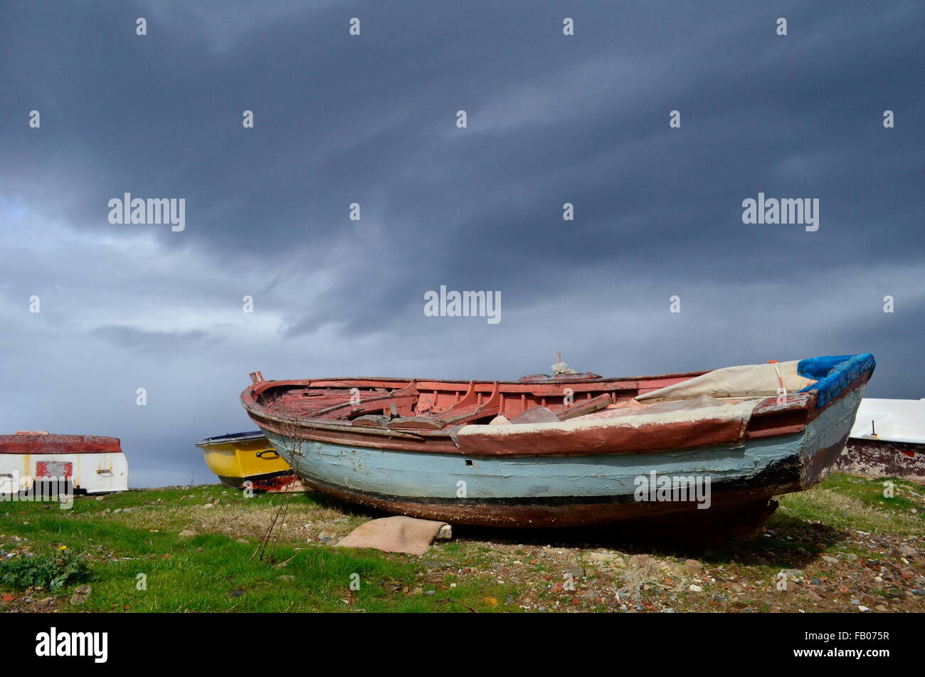 boat under dark rain clouds Stock Photo - Alamy