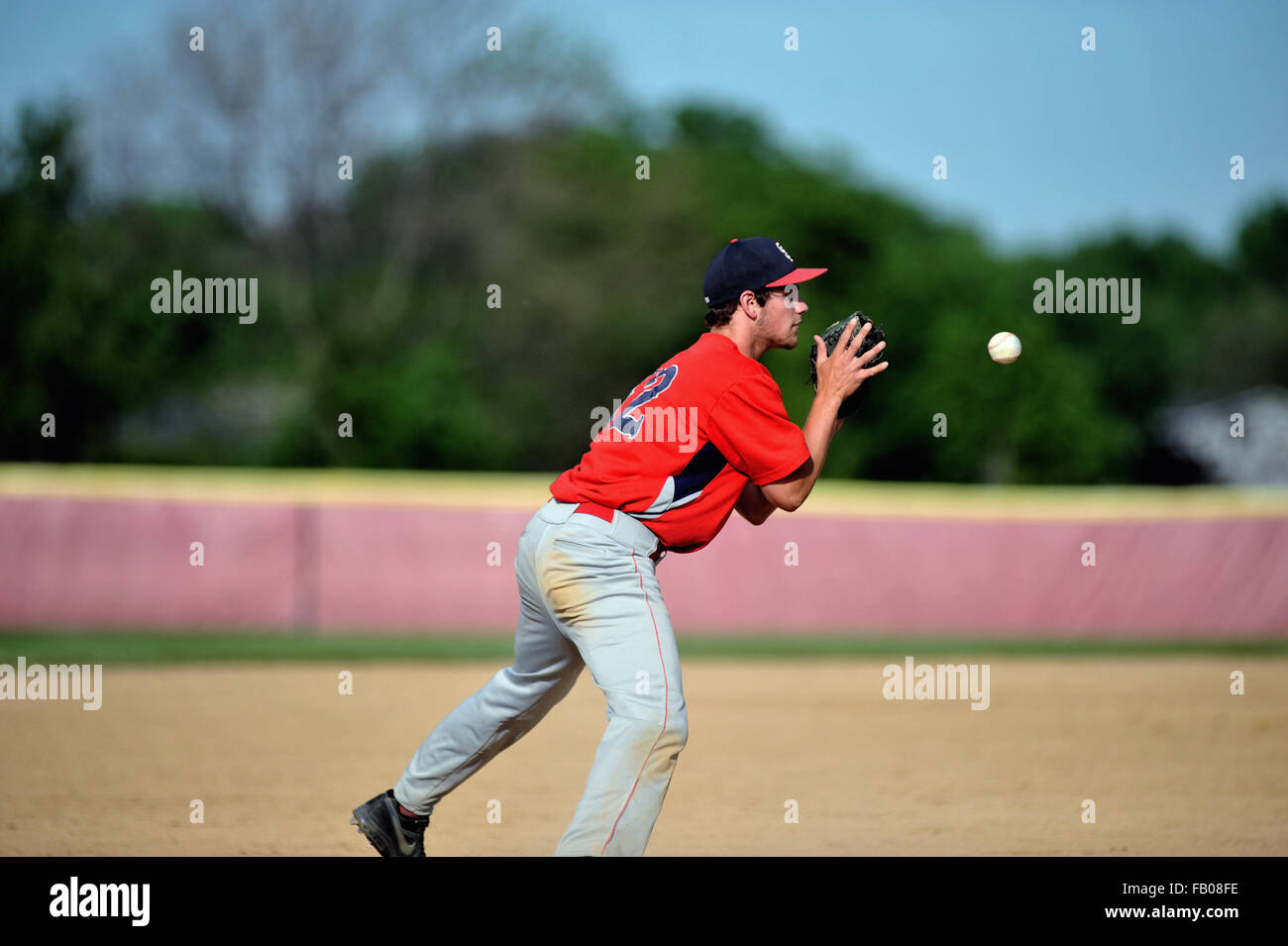 Third baseman fields a high hopping ground ball before throwing on to ...