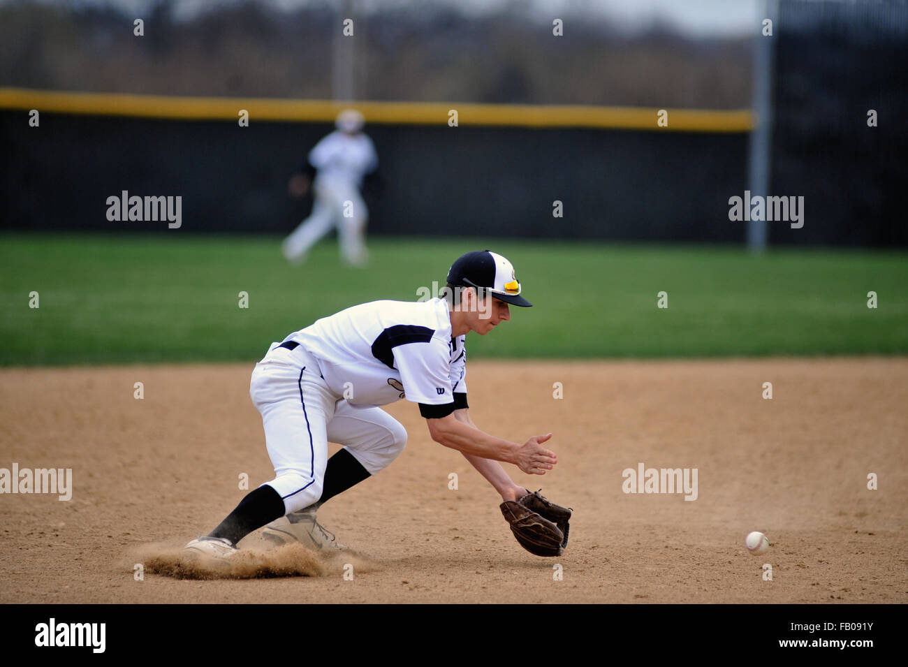 A high school shortstop plants his feet after gliding to his right to ...