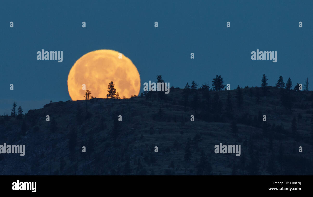 Moon setting over a rugged hillside reveals the awe inspiring details ...