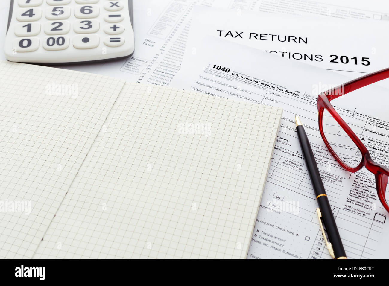 Tax return form 2015 with blank notebook and pen and calculator Stock ...