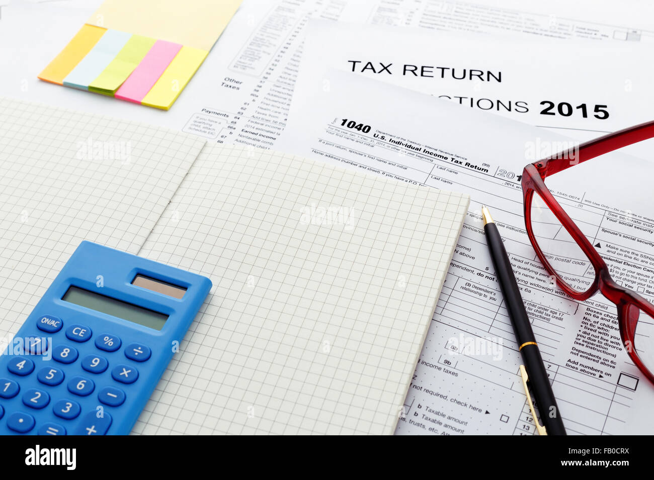 Tax return form 2015 with blank notebook and pen and calculator Stock ...
