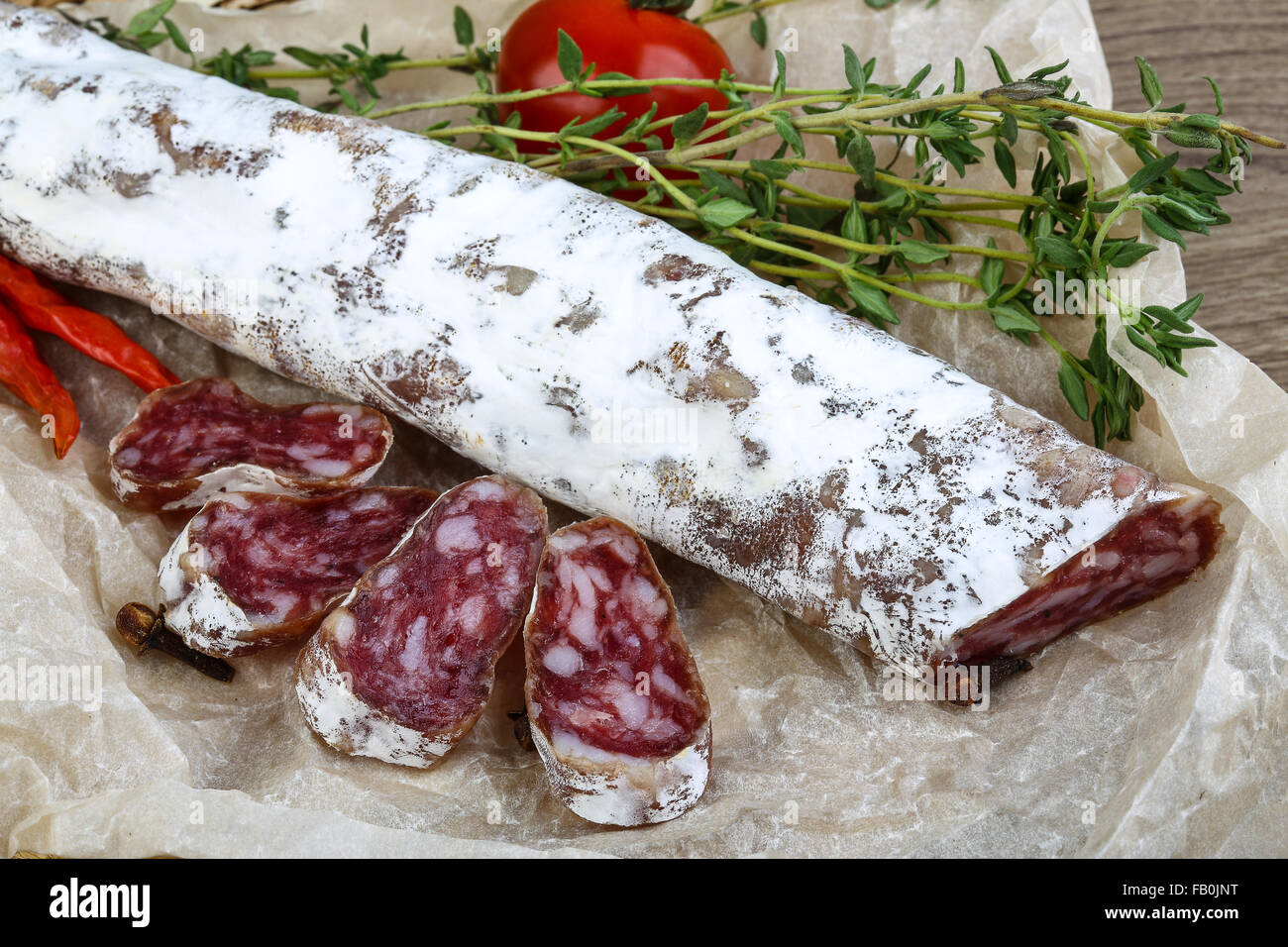 Traditional Spanish sausages- fuet with thyme leaves on the wood ...