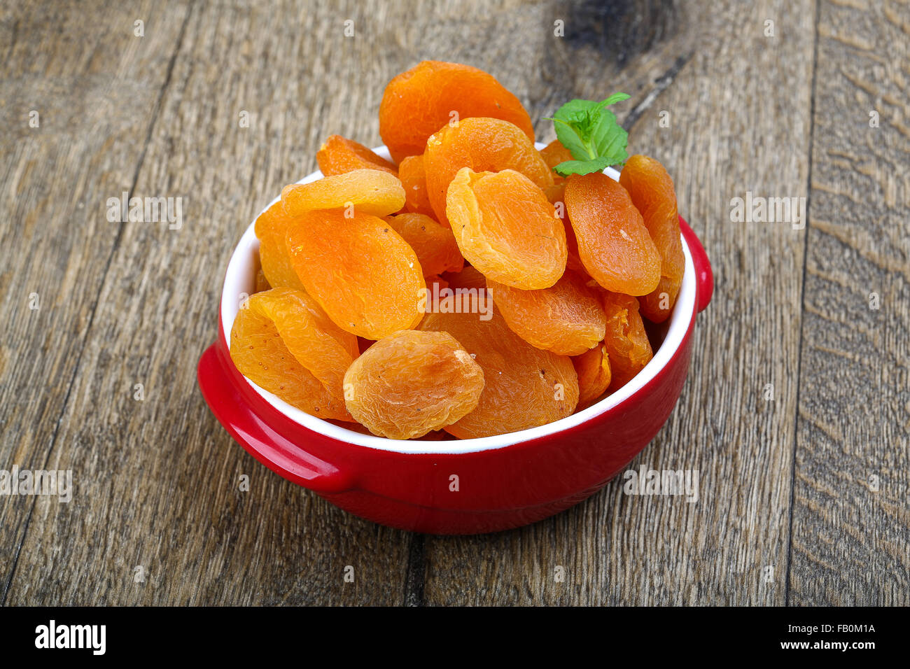 Dried apricots in the bowl on the wood background Stock Photo - Alamy