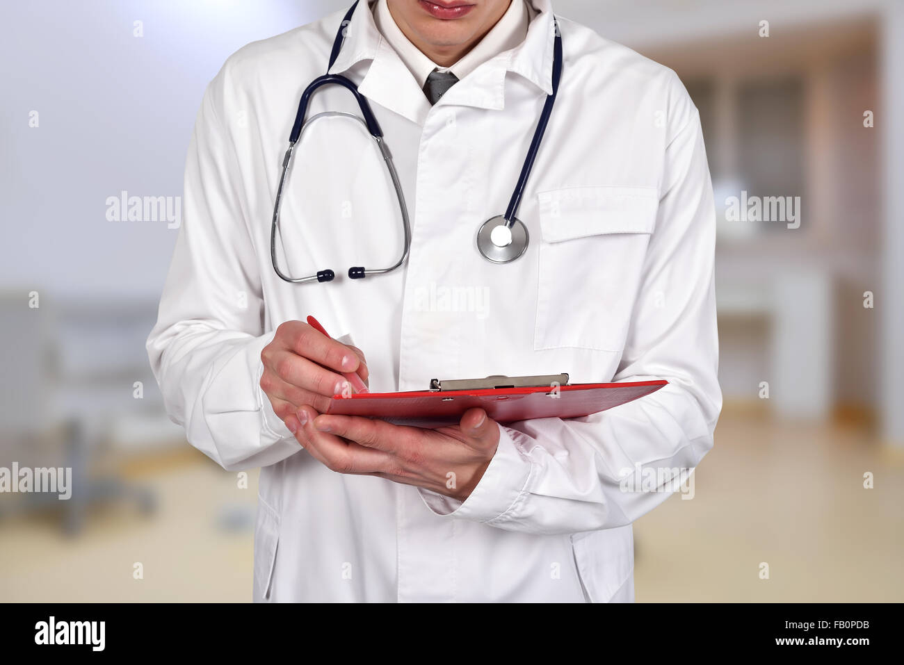 Young doctor with clipboard standing in clinic Stock Photo - Alamy