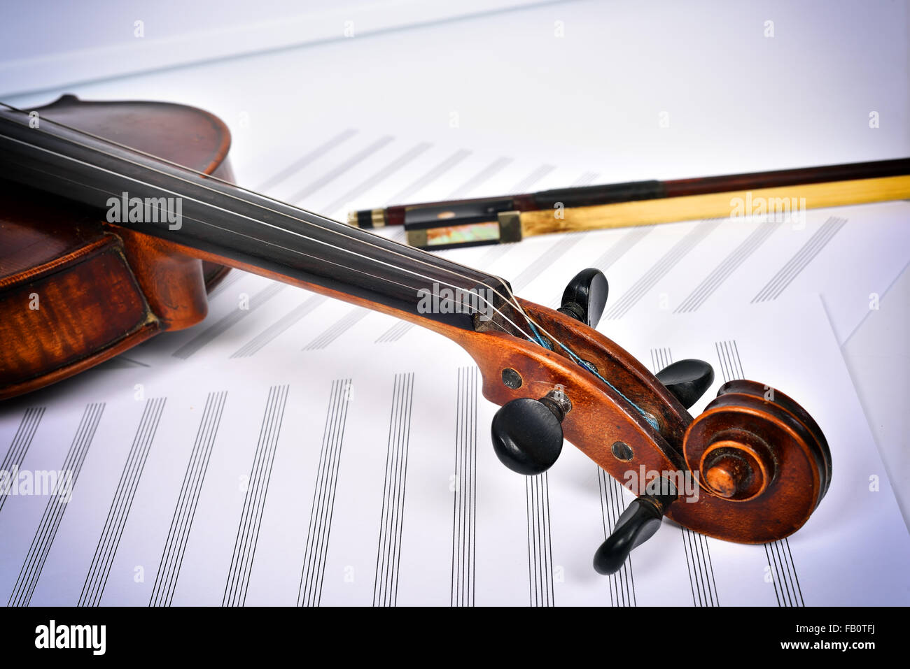 Violin lying at an angle on the notes, close up Stock Photo - Alamy