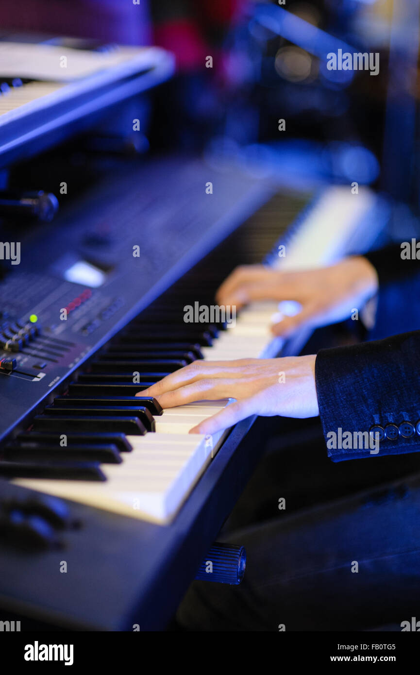 hands of musician playing keyboard in concert with shallow depth of ...