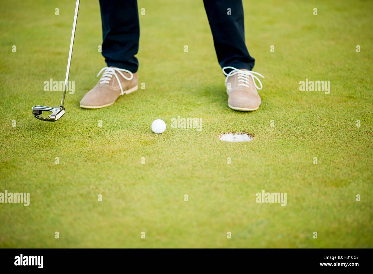 Golf ball, putter and boy's legs on green Stock Photo - Alamy