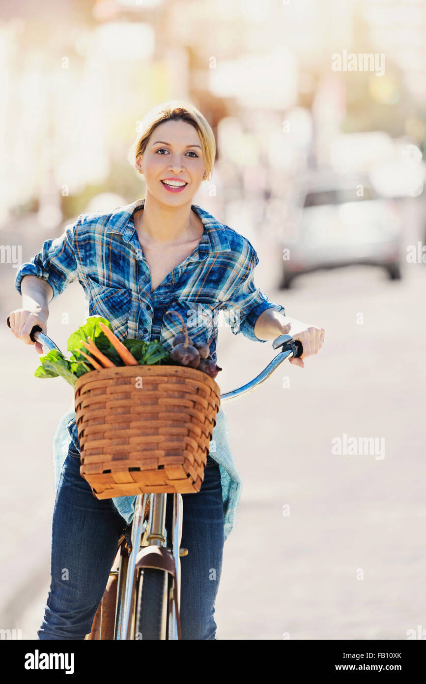 Portrait of young woman standing with bicycle Stock Photo - Alamy