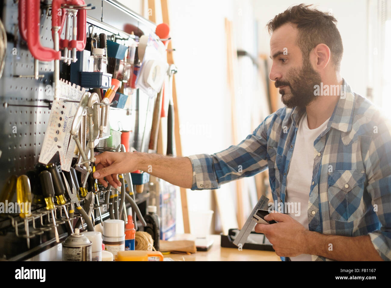 Man choosing tools in workshop Stock Photo - Alamy