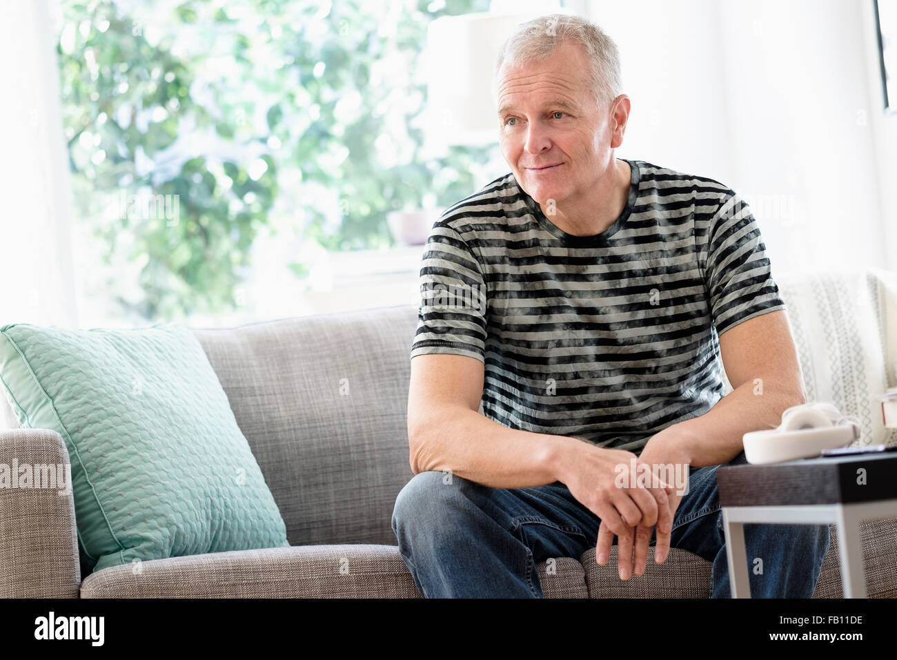 Man sitting home on sofa hi-res stock photography and images - Alamy