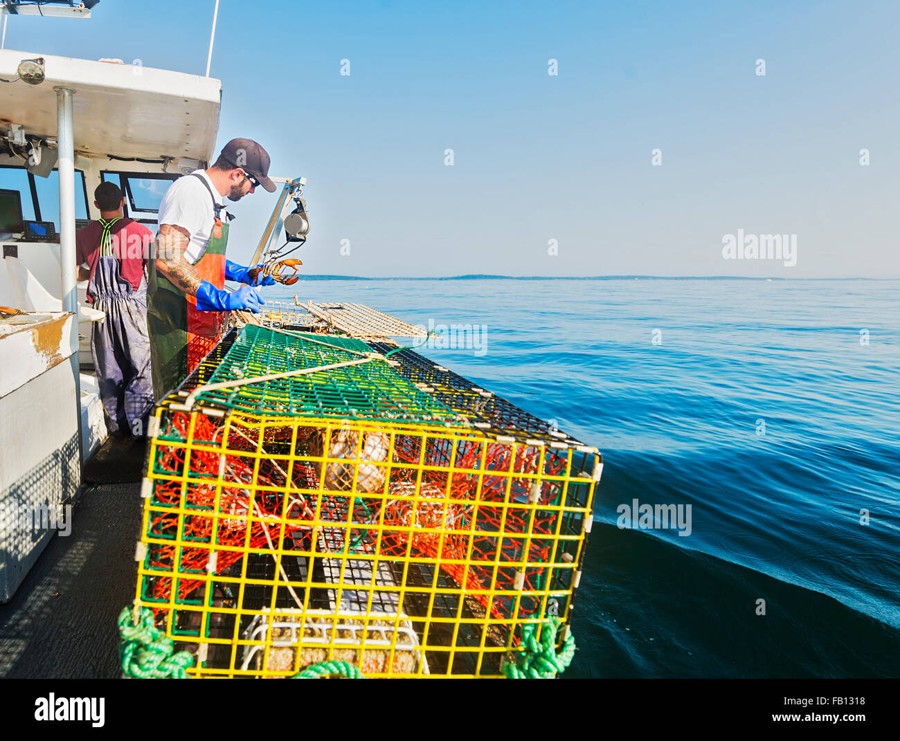 Two fishermen working on boat Stock Photo - Alamy