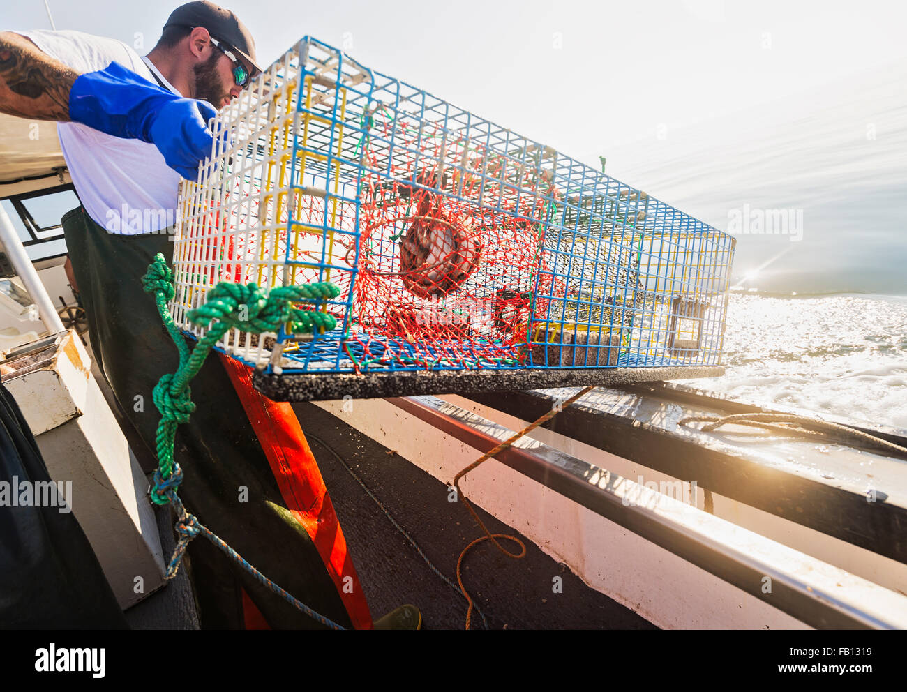 Fisherman throwing lobster trap Stock Photo - Alamy