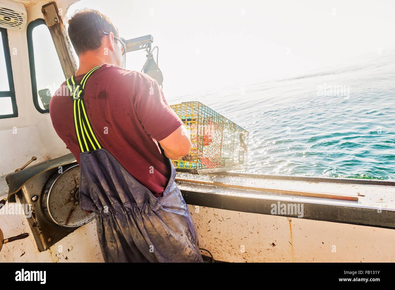 Fisherman throwing lobster trap Stock Photo - Alamy