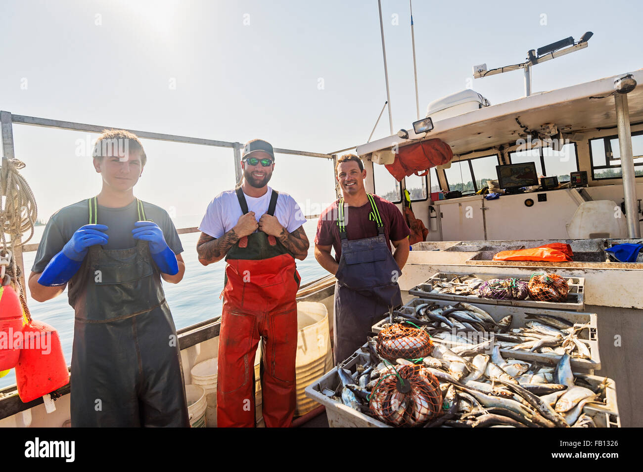 Portrait of three fishermen standing on boat Stock Photo - Alamy