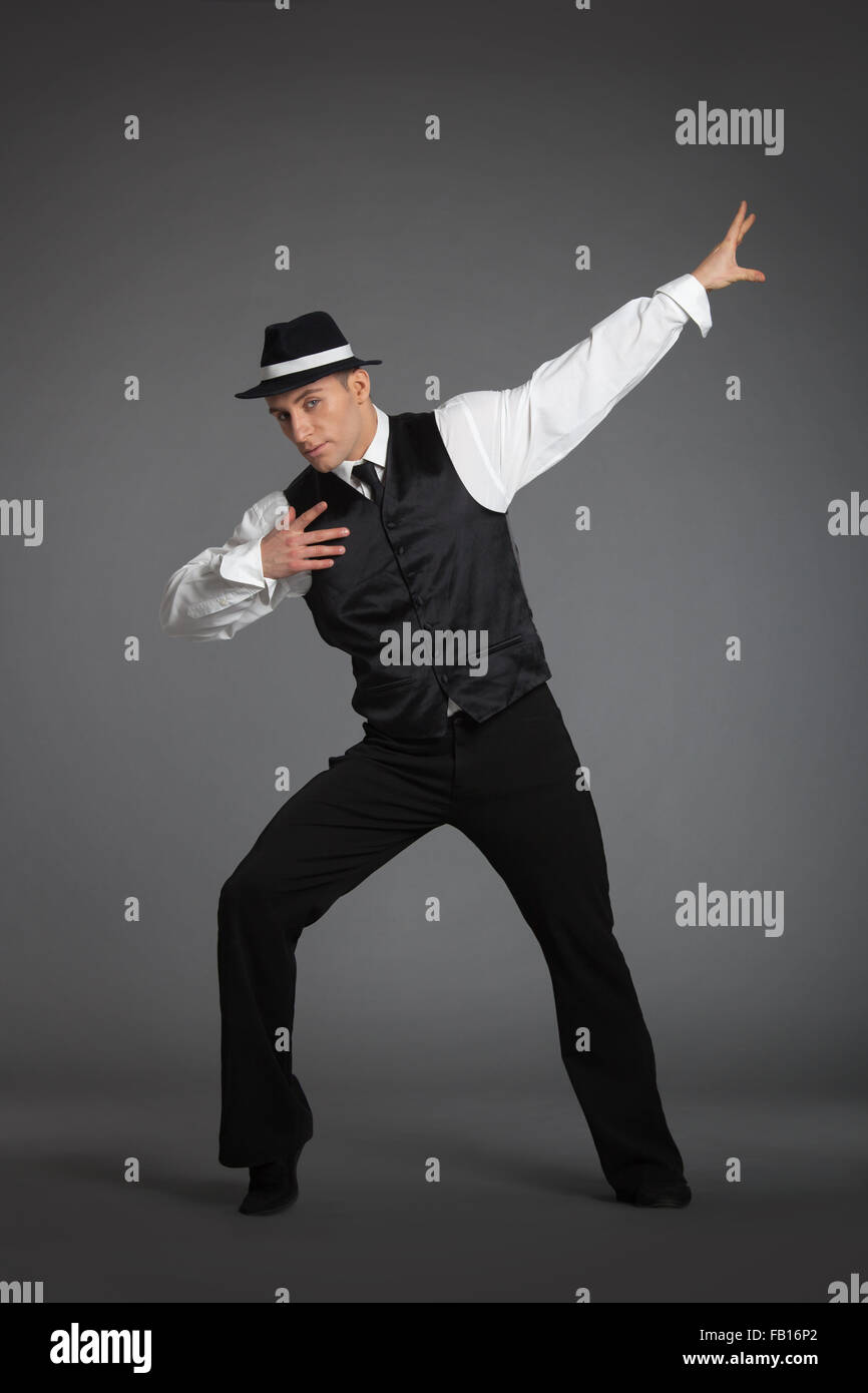 Young male professional dancer dancing in studio isolated on gray ...