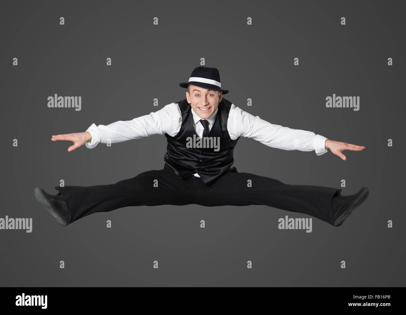 Young male professional dancer dancing in studio isolated on gray ...