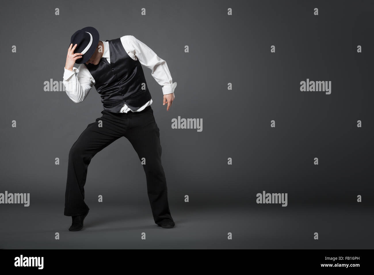Young male professional dancer dancing in studio isolated on gray ...