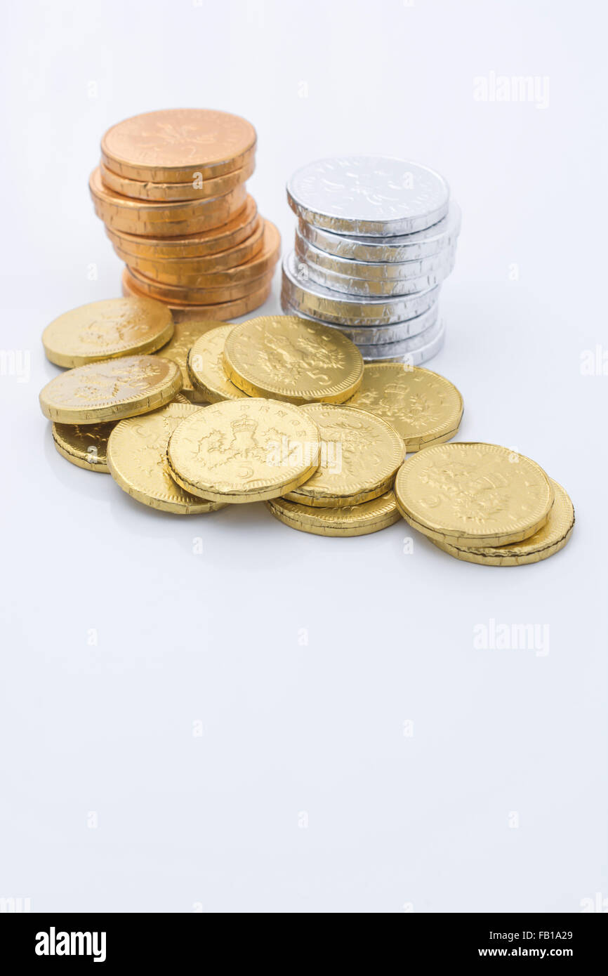 Stack of chocolate money covered in foil. Yellow 5p at front, while 2 ...