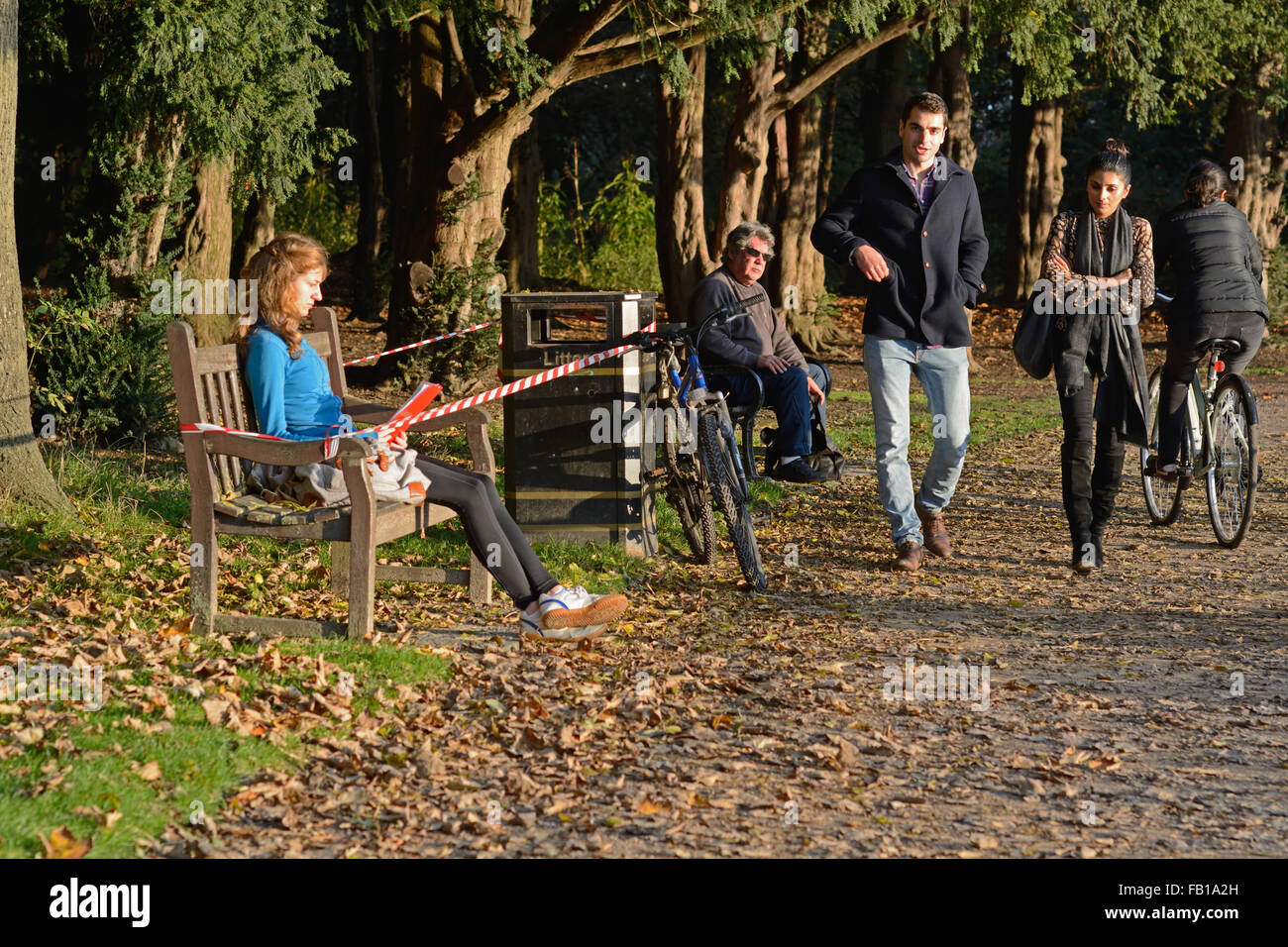 Girl sitting on roped off bench Stock Photo - Alamy