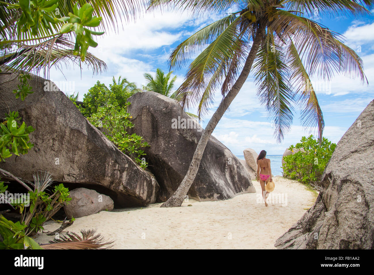 Beautiful woman posing on the famous Source D´Argent white sandy beach ...
