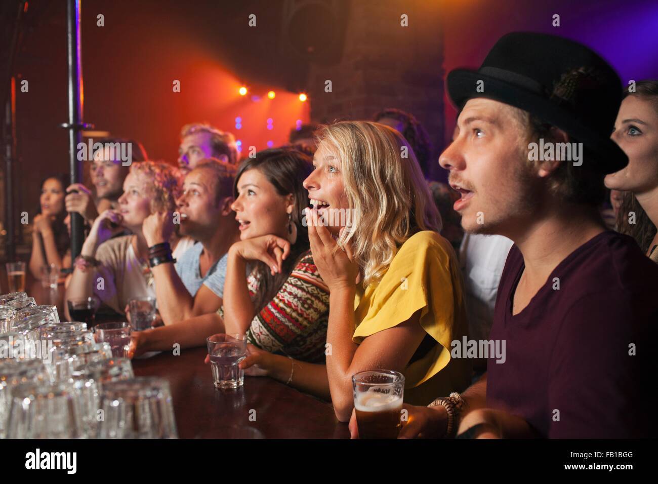 Group of friends watching performance in club Stock Photo - Alamy