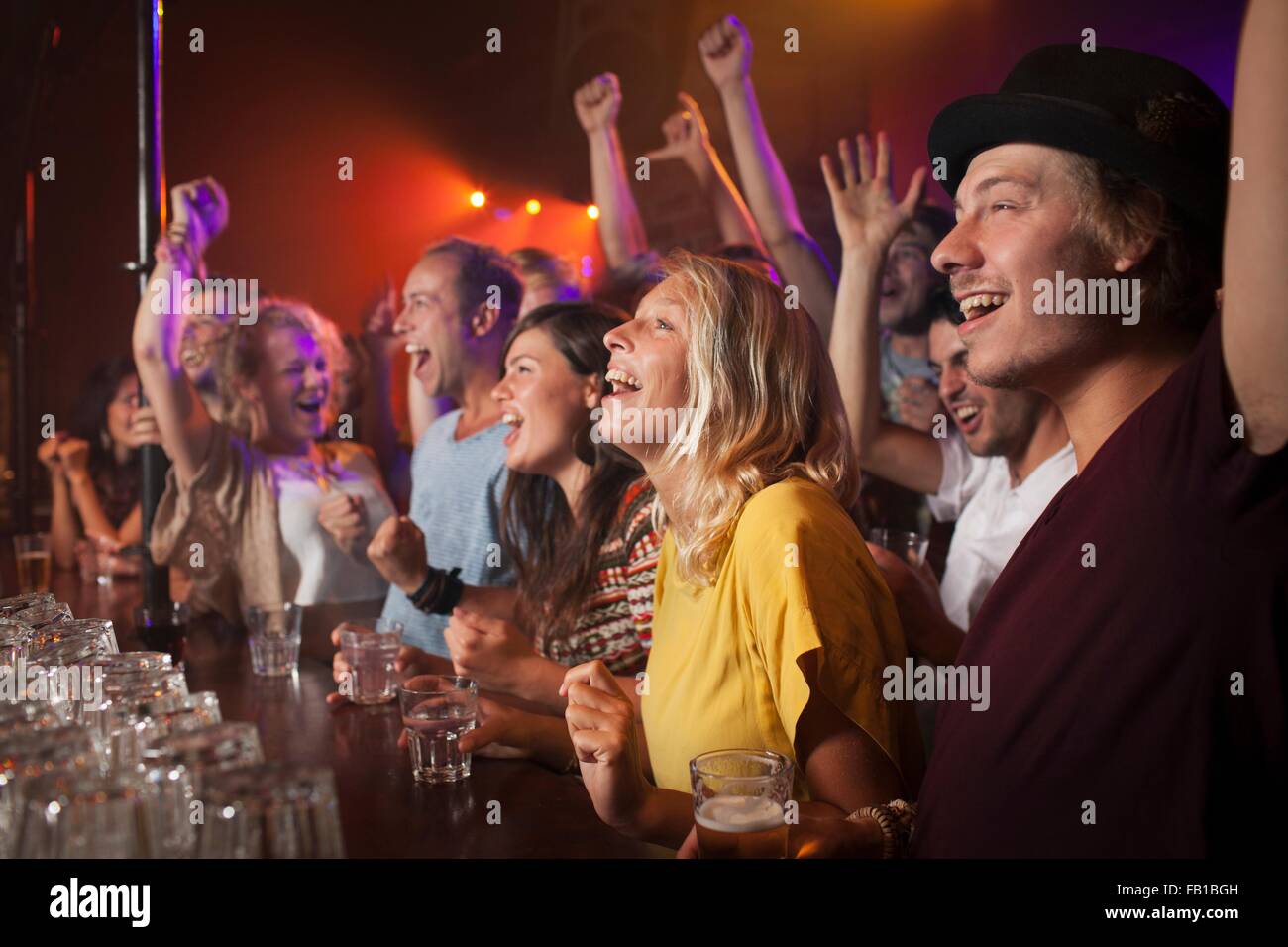 Group of friends watching performance in club Stock Photo - Alamy