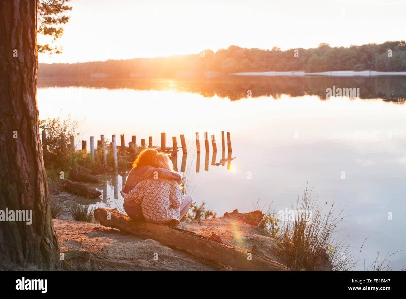 Young couple enjoying scenery by lake Stock Photo - Alamy