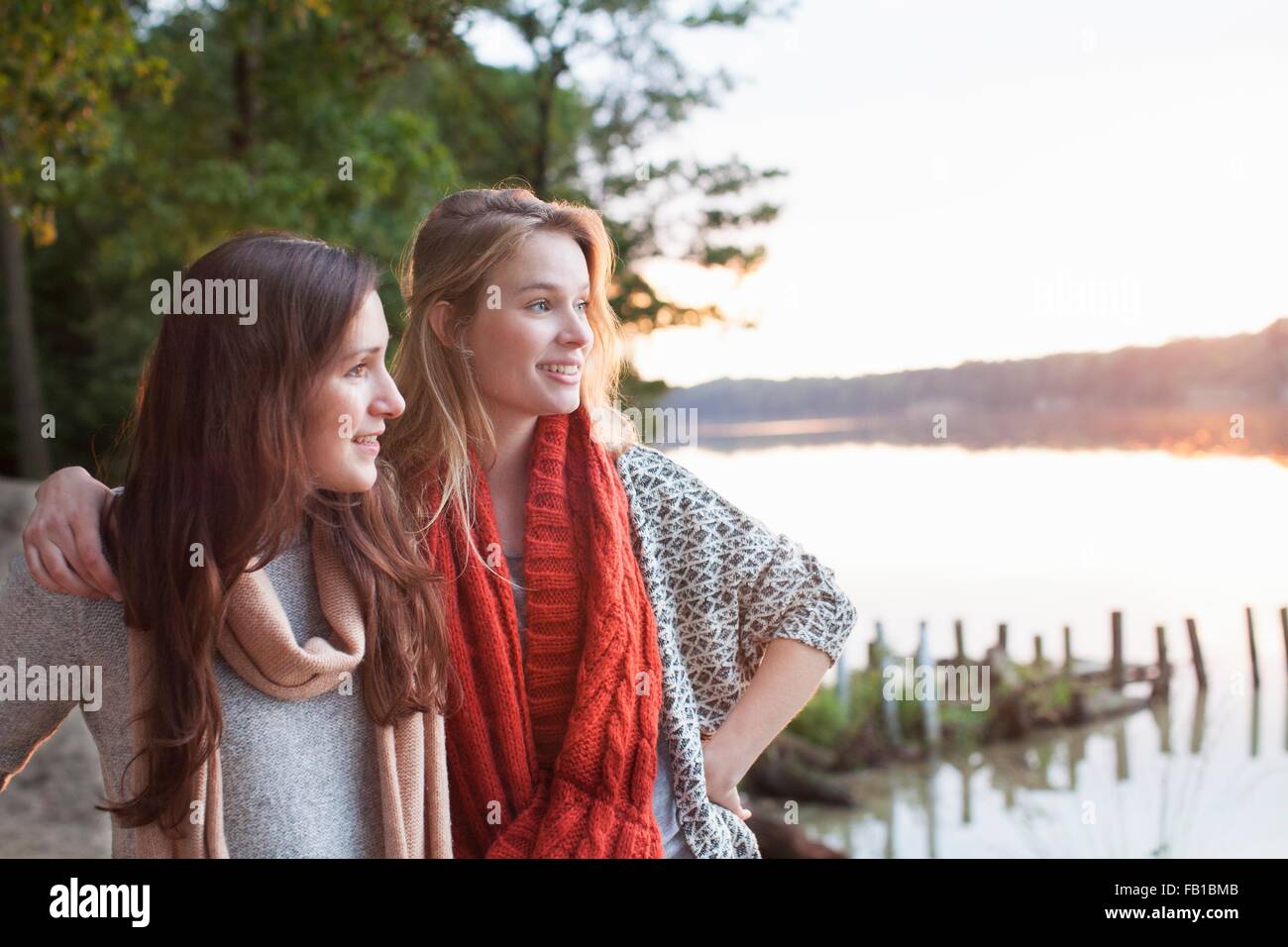 Young women enjoying scenery by lake Stock Photo - Alamy