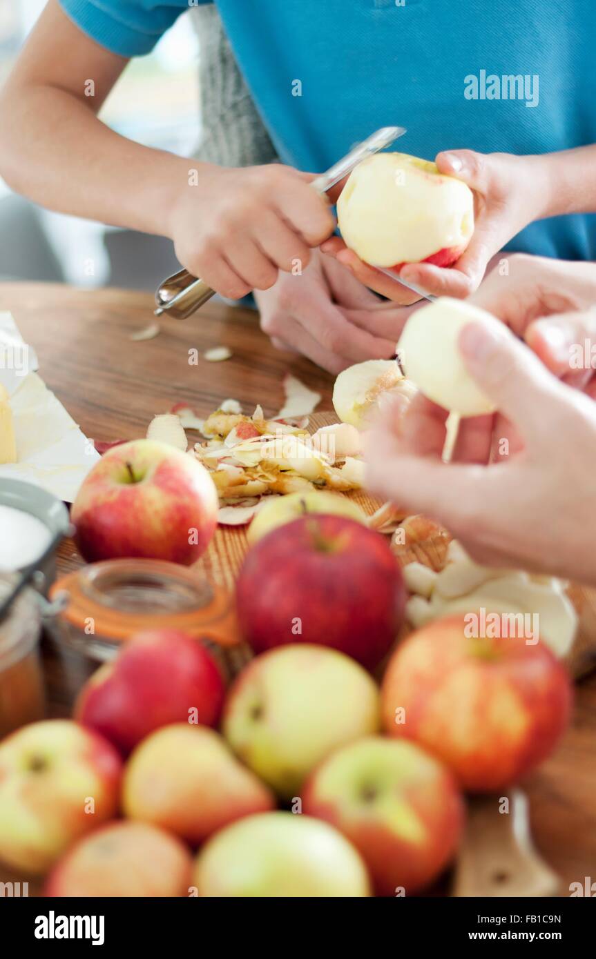 Cropped shot of father and sons hands peeling organic apples Stock ...