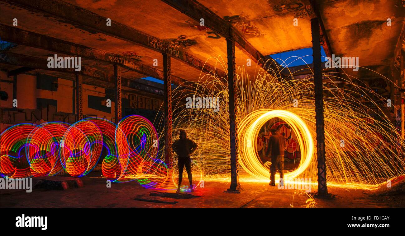 Man and woman creating multi-color and golden spark light trails in ...