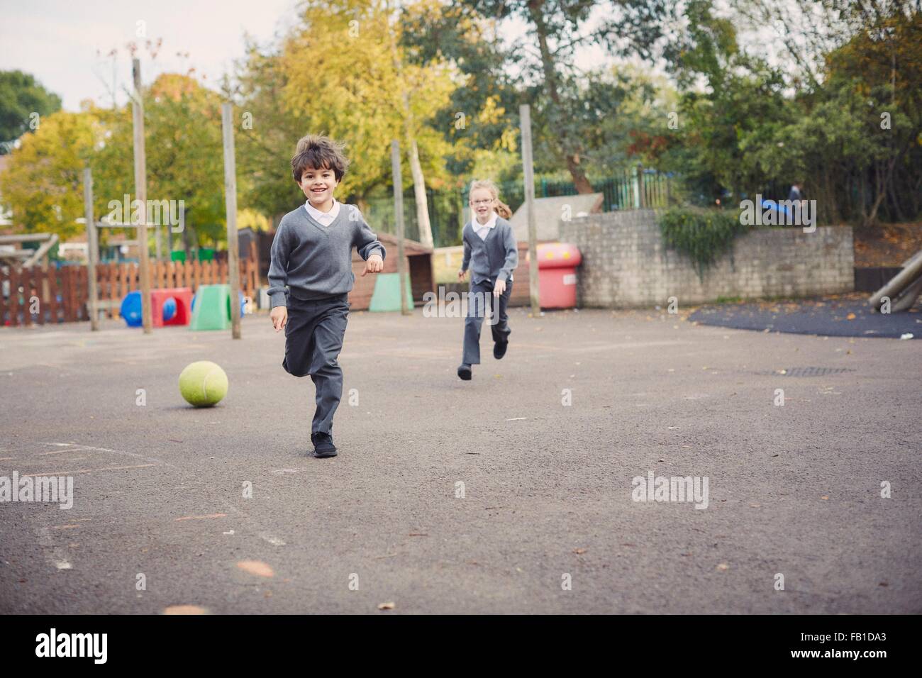 Elementary schoolboy and girl running in playground Stock Photo - Alamy