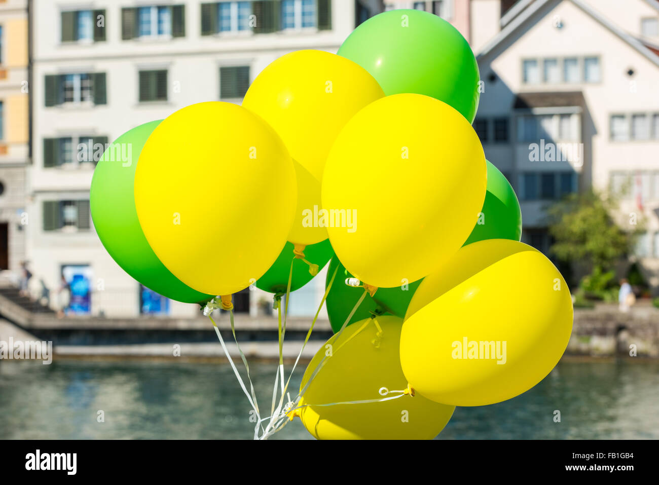 Bright yellow and green balloons on a city street event in summer Stock ...