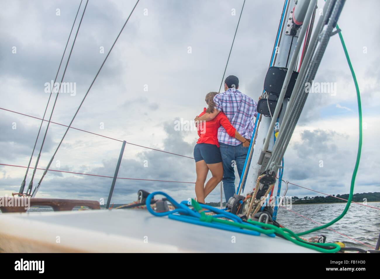 Rear view of couple on bow of arms around each other Stock Photo - Alamy