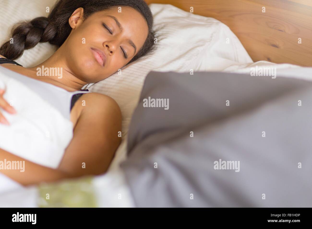 High angle view of young woman lying on back in bed eyes closed sleeping Stock Photo - Alamy
