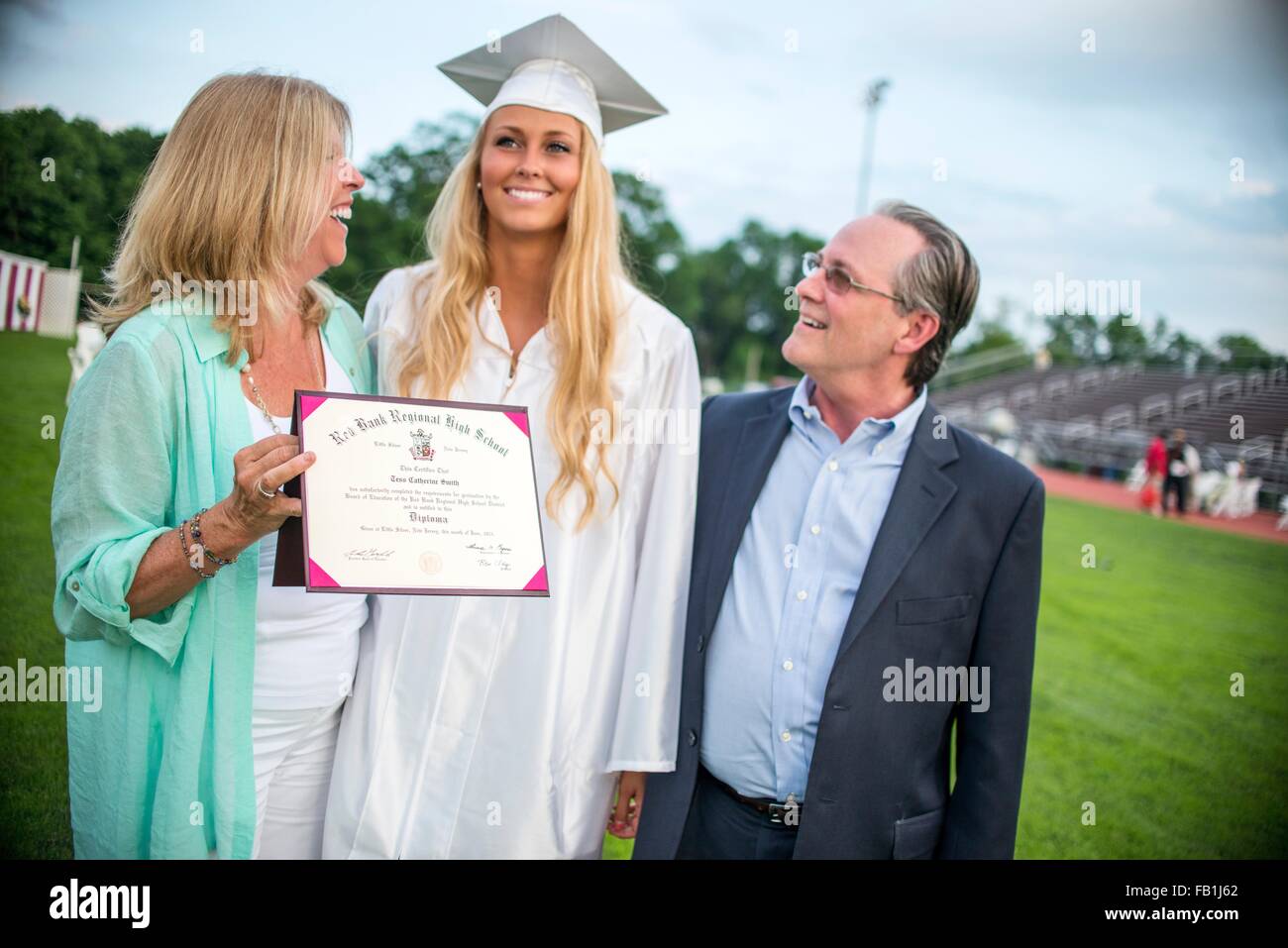 Young female graduate with parents at graduation ceremony Stock Photo ...