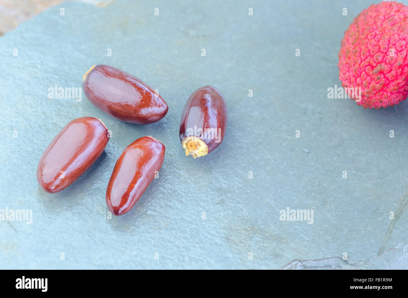 Lychee pits on a stone background Stock Photo - Alamy