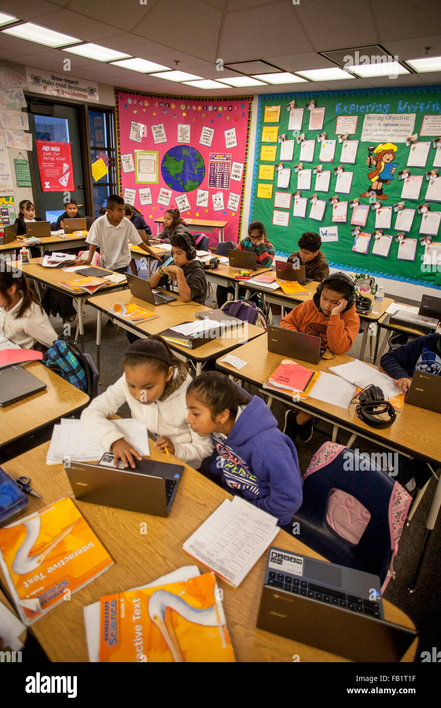 Hispanic third grade students enter information in their Google ...