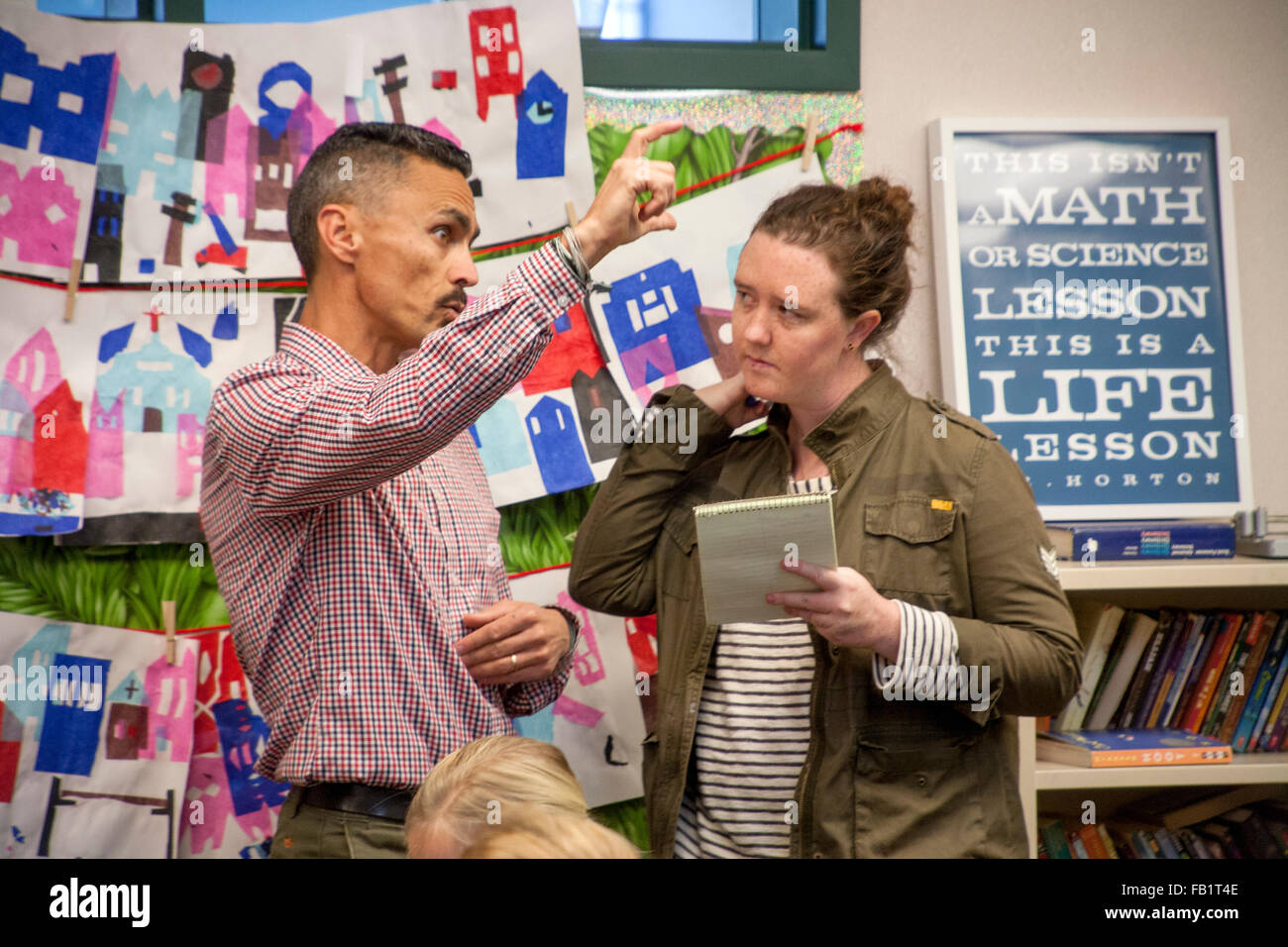 A young female newspaper reporter interviews a Hispanic fifth grade ...