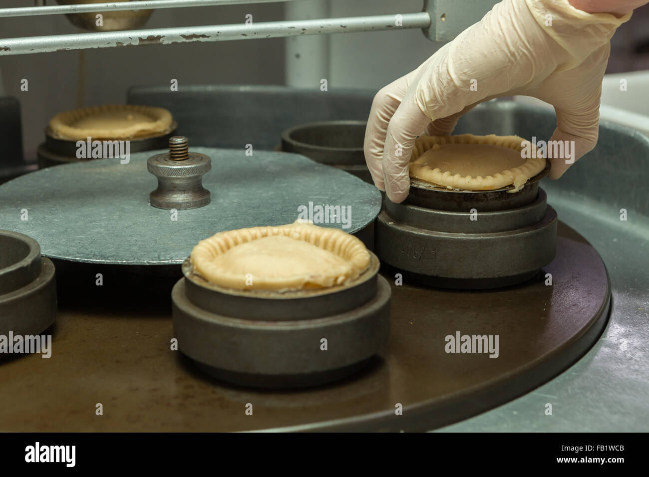 Making pork pies in a factory with an automated machine Stock Photo - Alamy